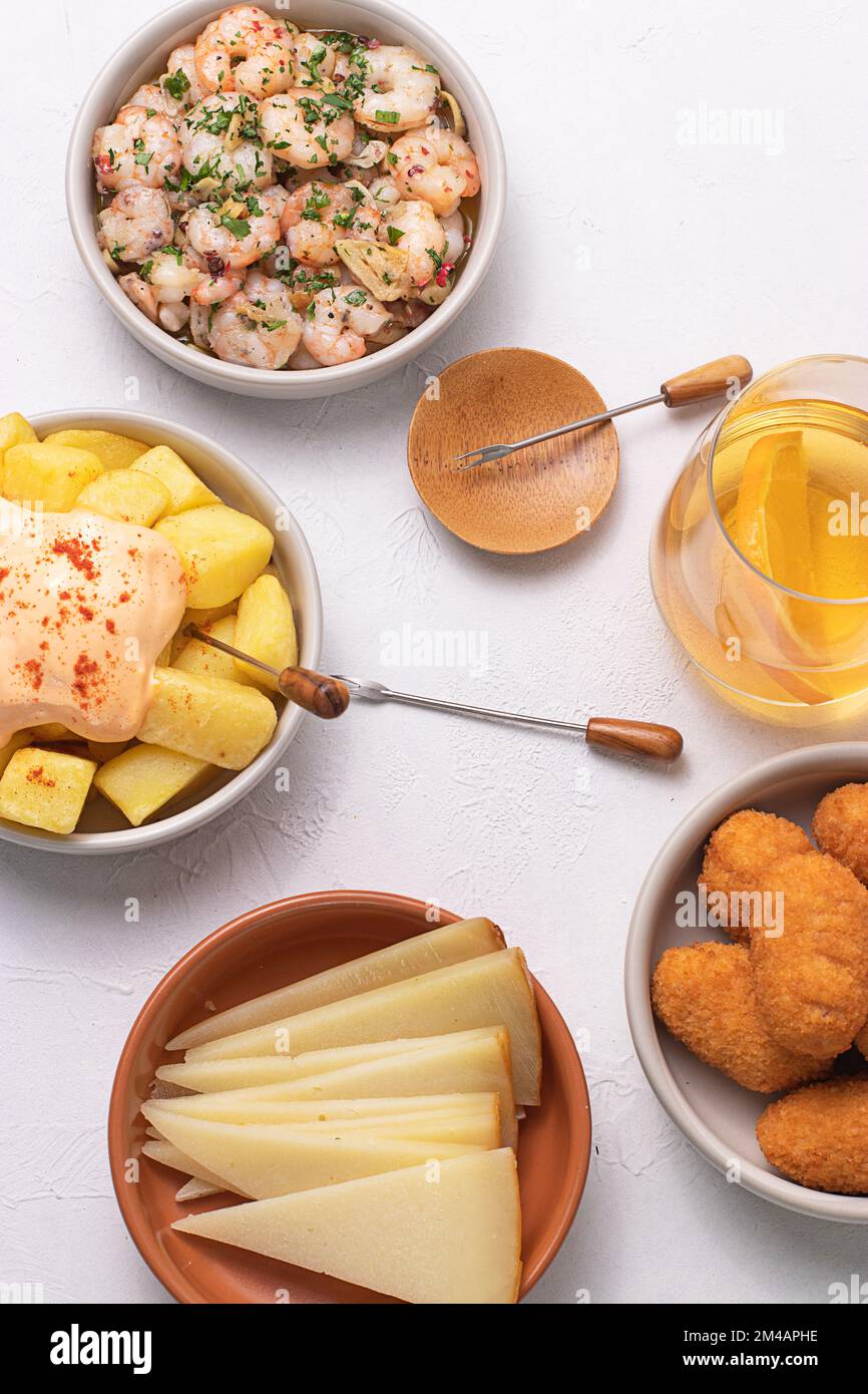 From above assorted traditional spanish tapas served on bowls on white ...