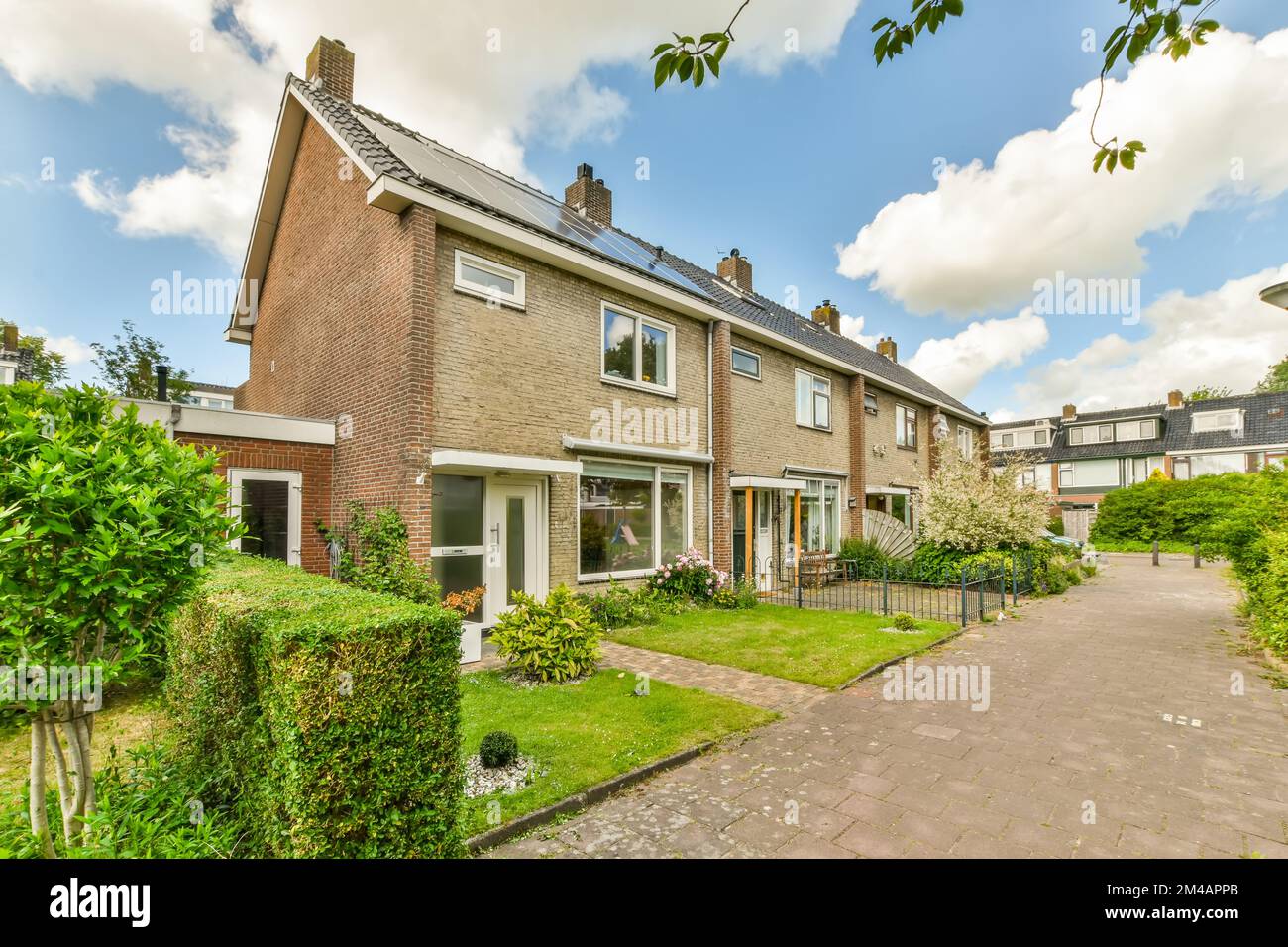 View of a street with houses lined up under a blue sky with clouds ...