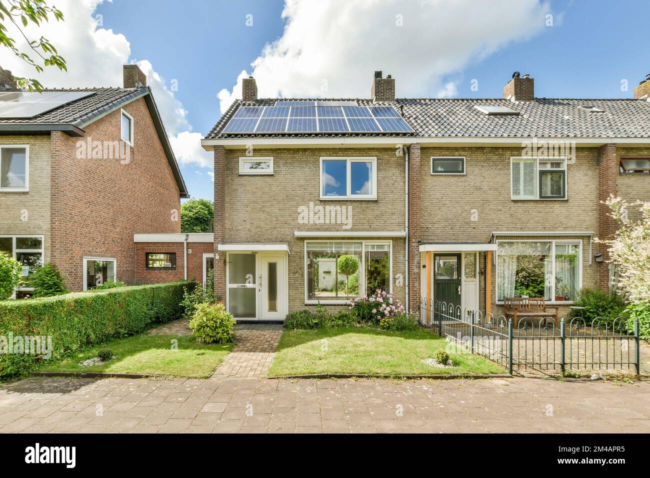 View of a street with houses lined up under a blue sky with clouds ...