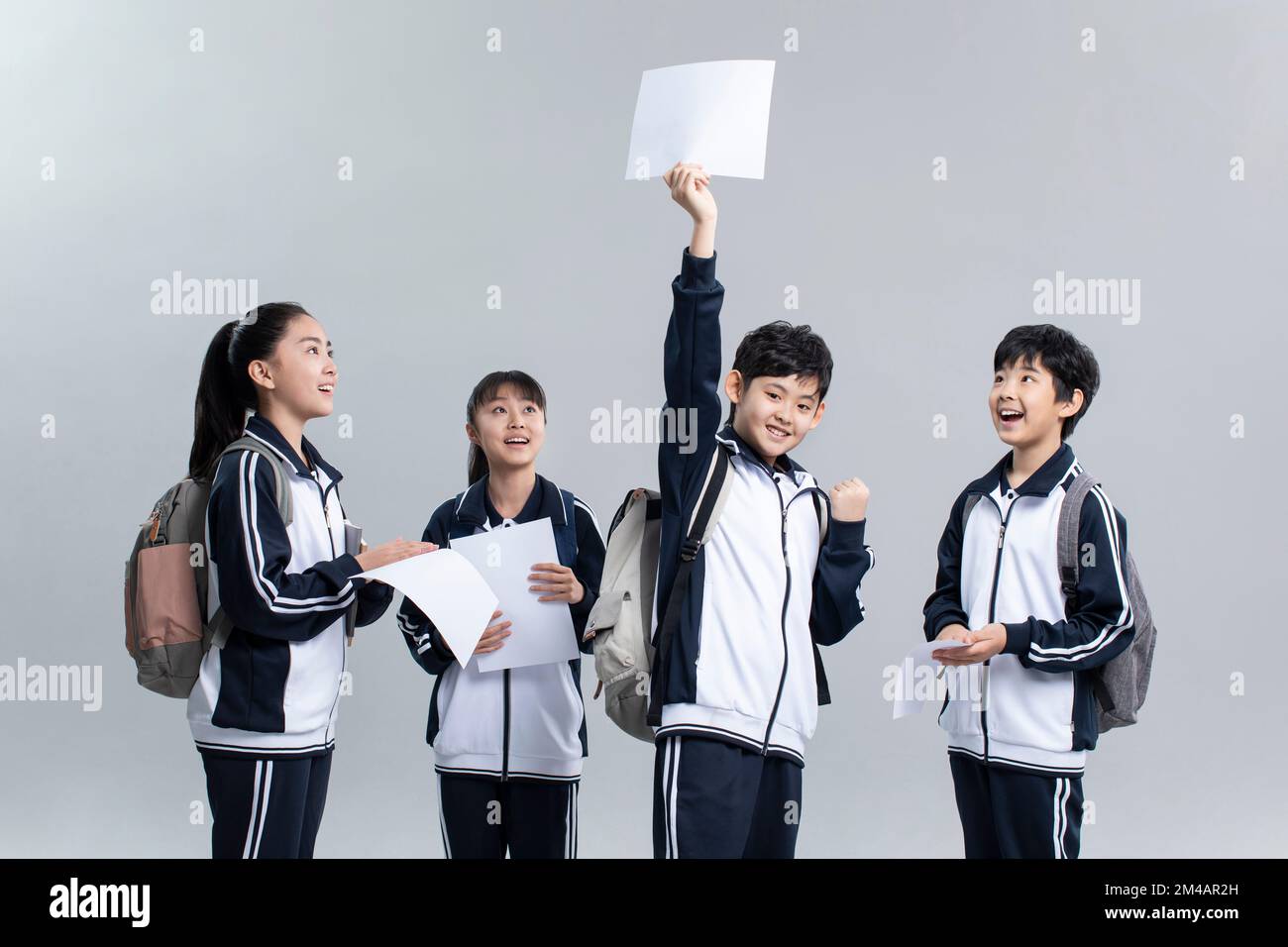 Cheerful Chinese students in uniform celebrating for their test results ...