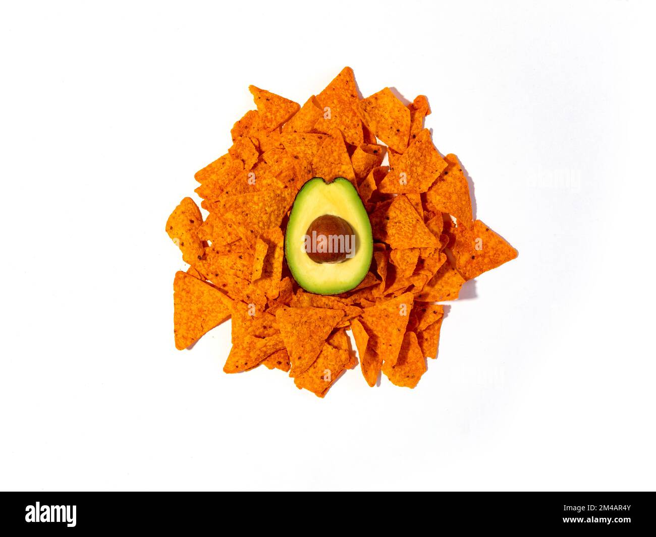 Top view of half of fresh avocado placed on pile of crunchy tortilla ...