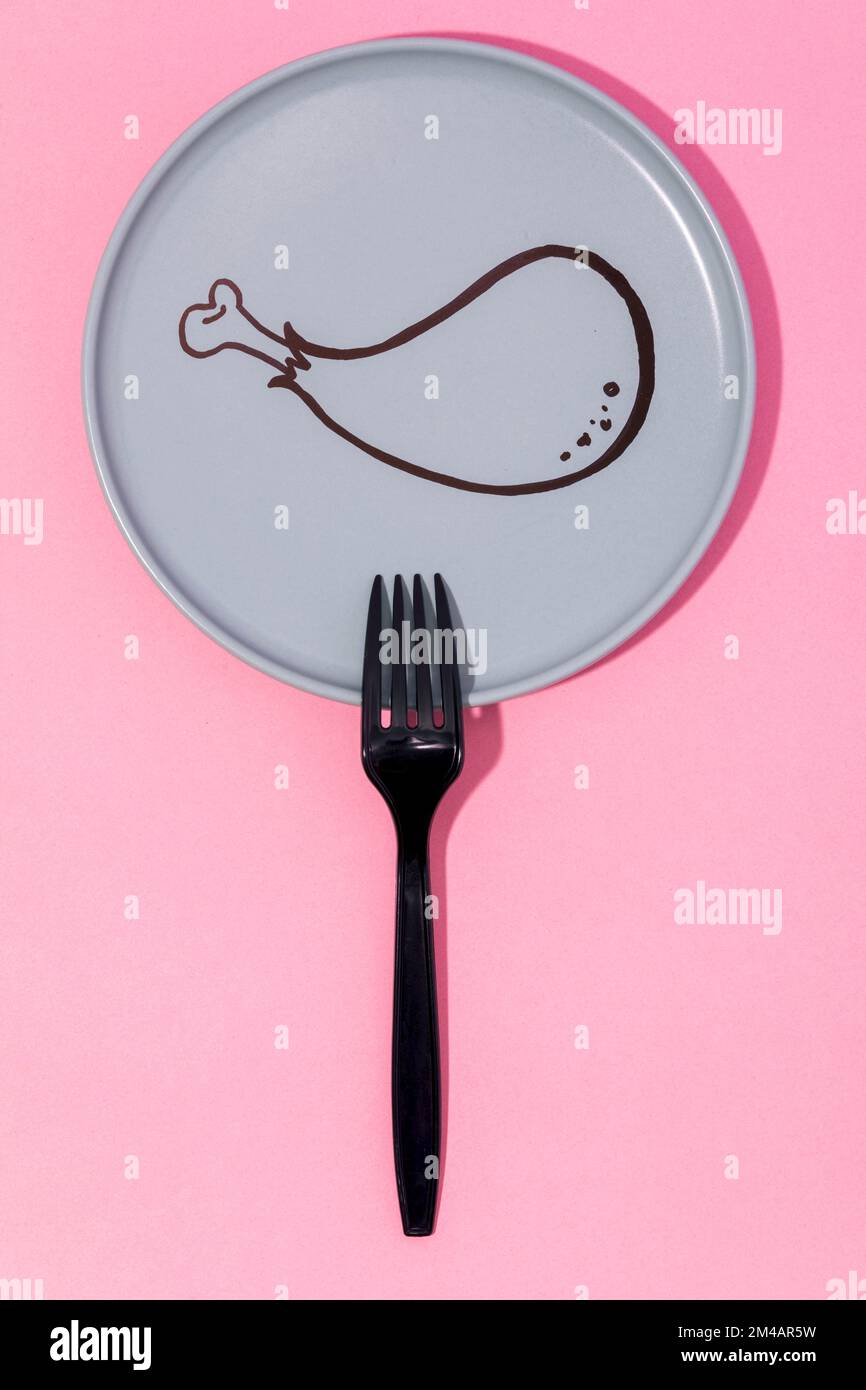 Top view of black plastic fork placed on pink table on gray plate with ...