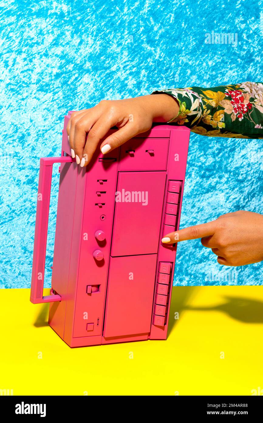 High angle of crop unrecognizable woman pushing button of bright pink ...