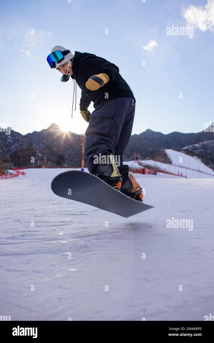 Young Chinese man snowboarding in ski resort Stock Photo - Alamy