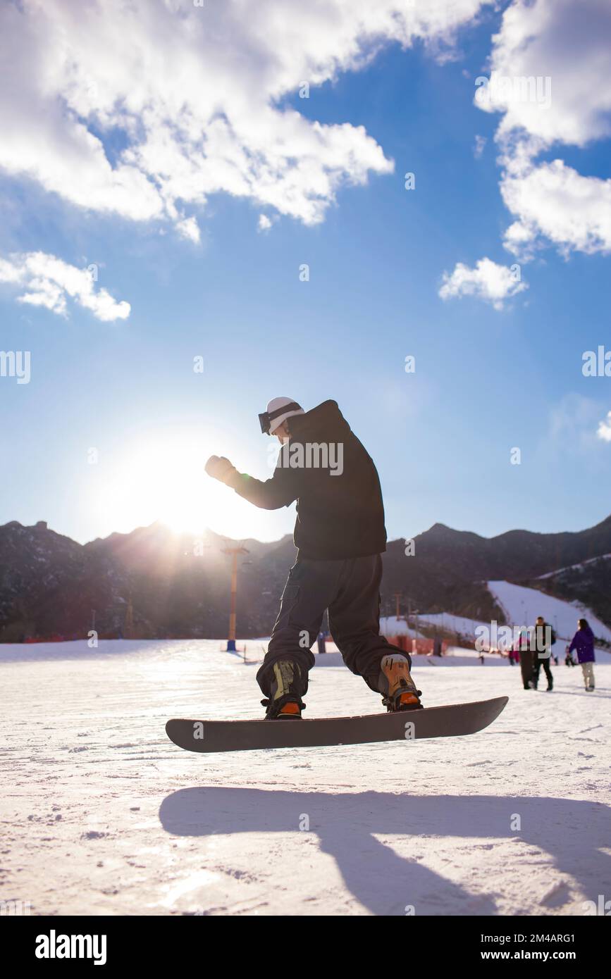 Young Chinese man snowboarding in ski resort Stock Photo - Alamy