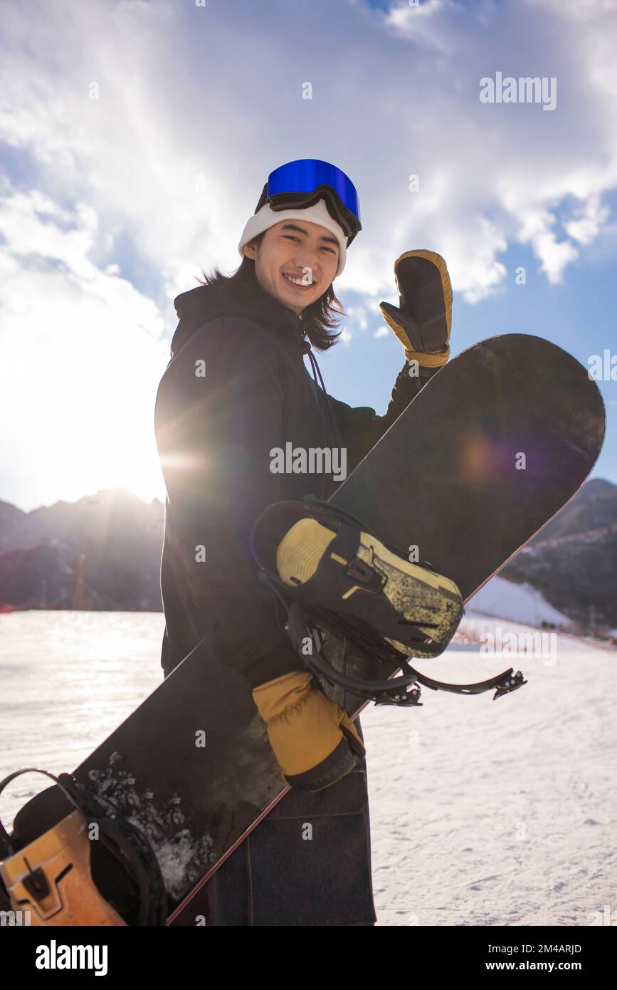 Young Chinese man with snowboard on the snow Stock Photo - Alamy
