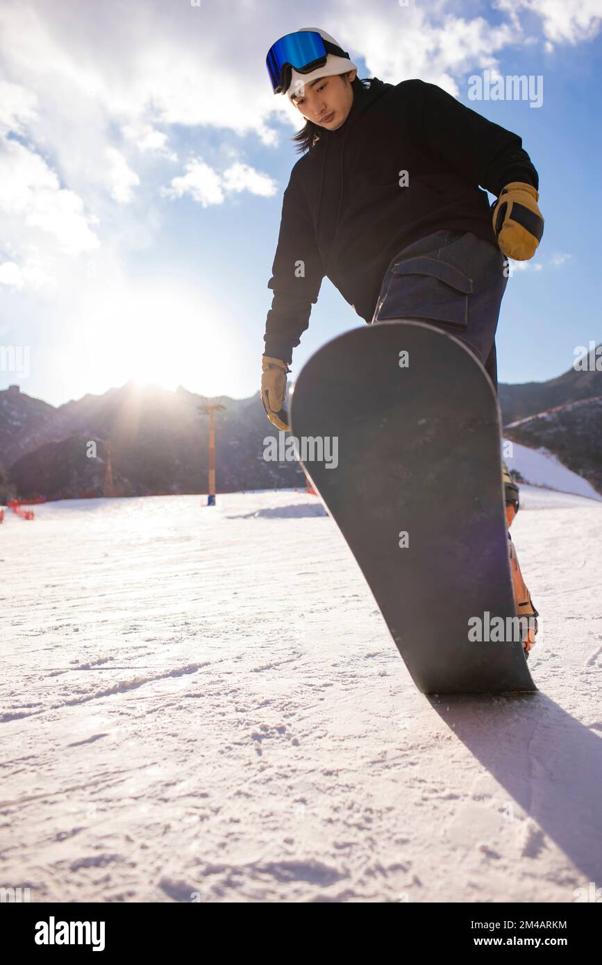 Young Chinese man snowboarding in ski resort Stock Photo - Alamy