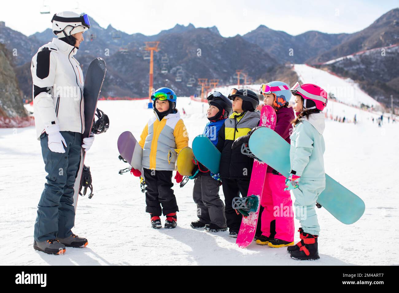 Chinese children learning how to snowboard with their coach Stock Photo ...