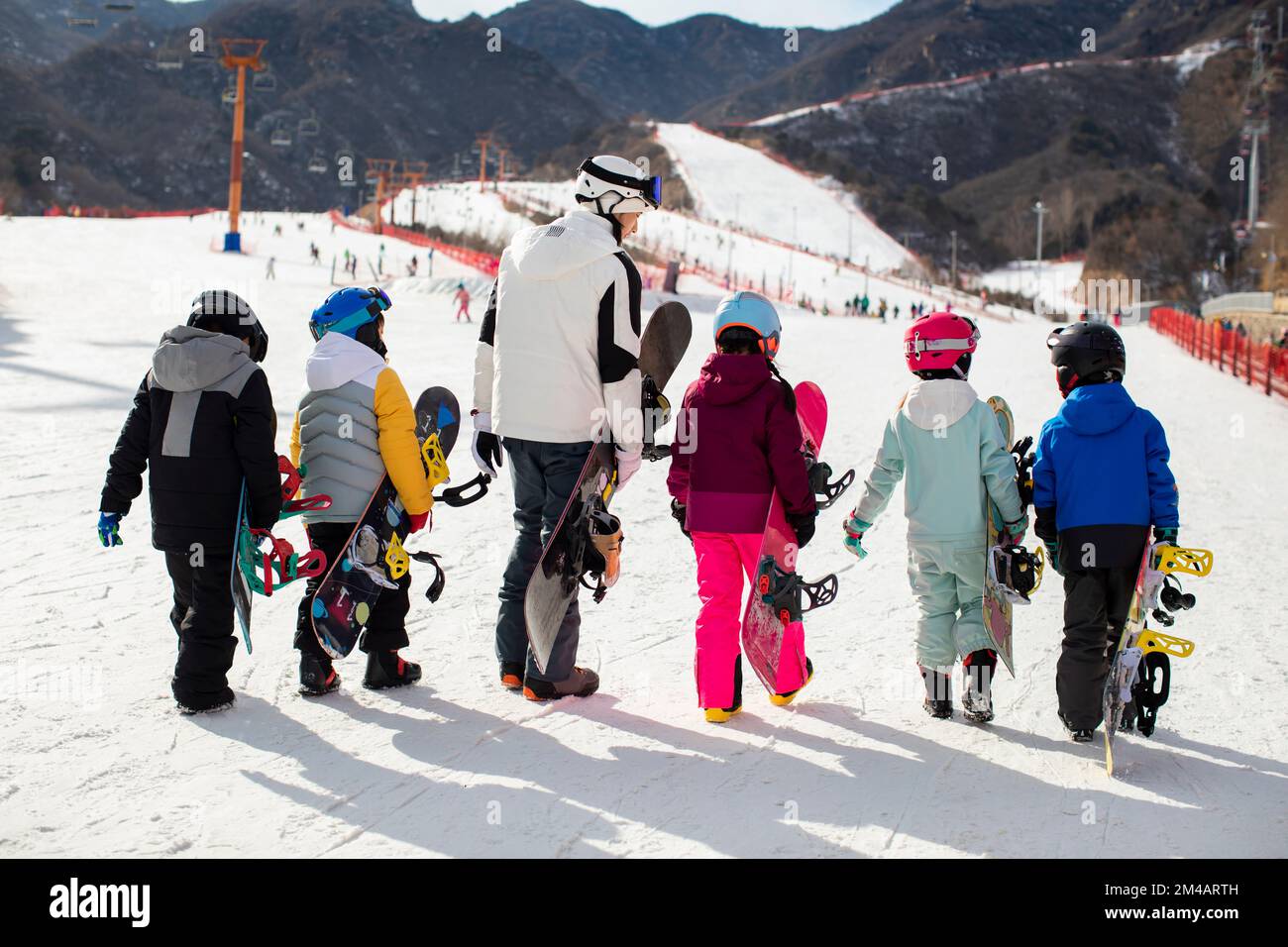 Chinese children learning how to snowboard with their coach Stock Photo ...