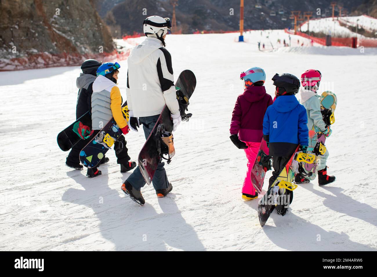 Chinese children learning how to snowboard with their coach Stock Photo ...