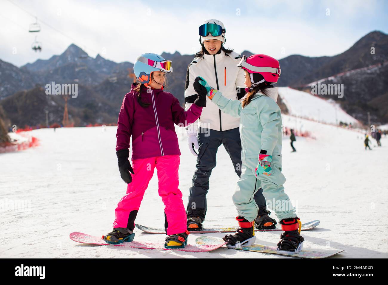 Chinese children learning how to snowboard with their coach Stock Photo ...