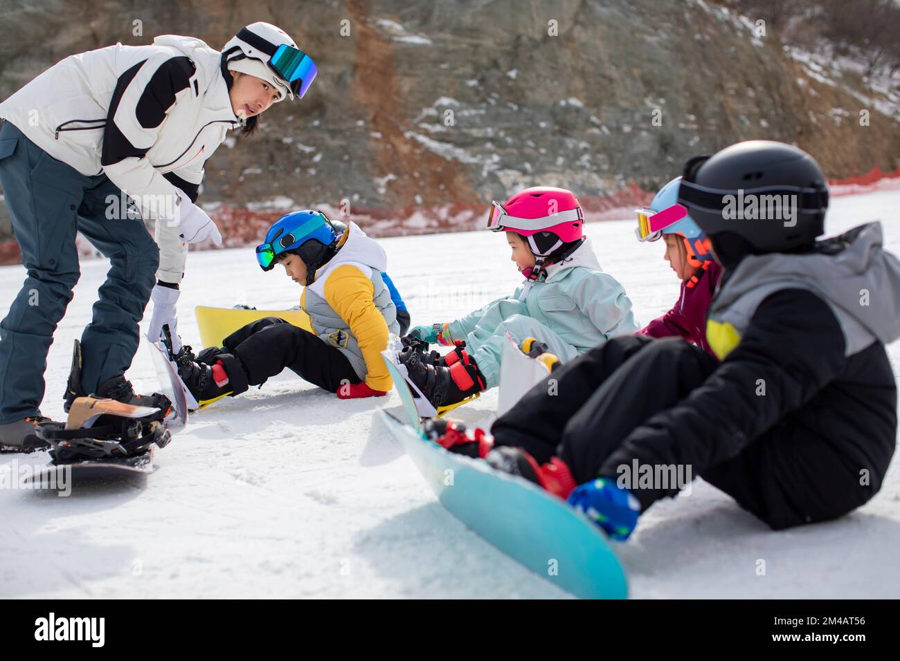 Chinese children learning how to snowboard with their coach Stock Photo ...