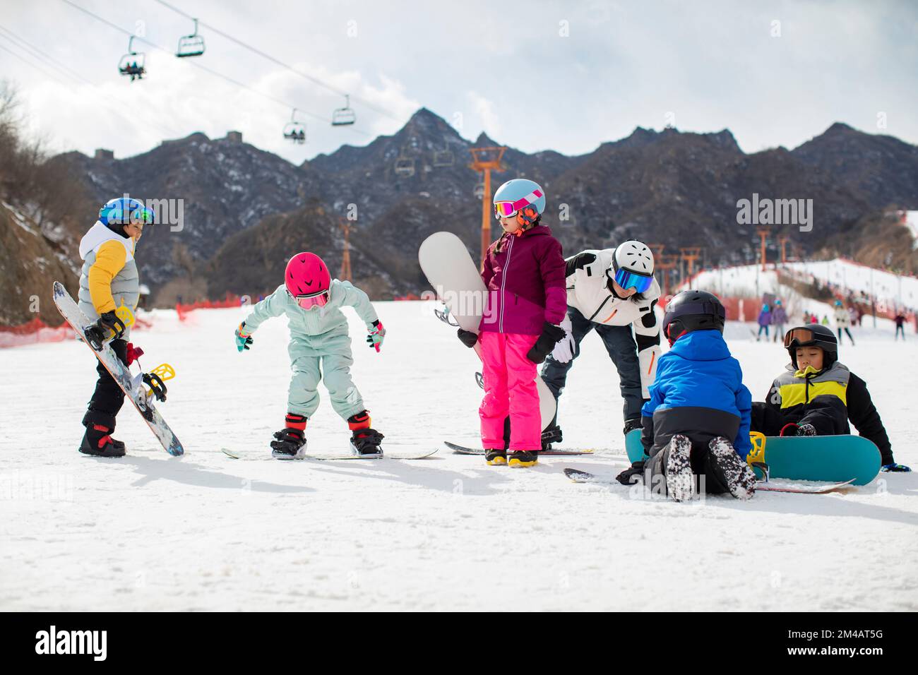 Chinese children learning how to snowboard with their coach Stock Photo ...