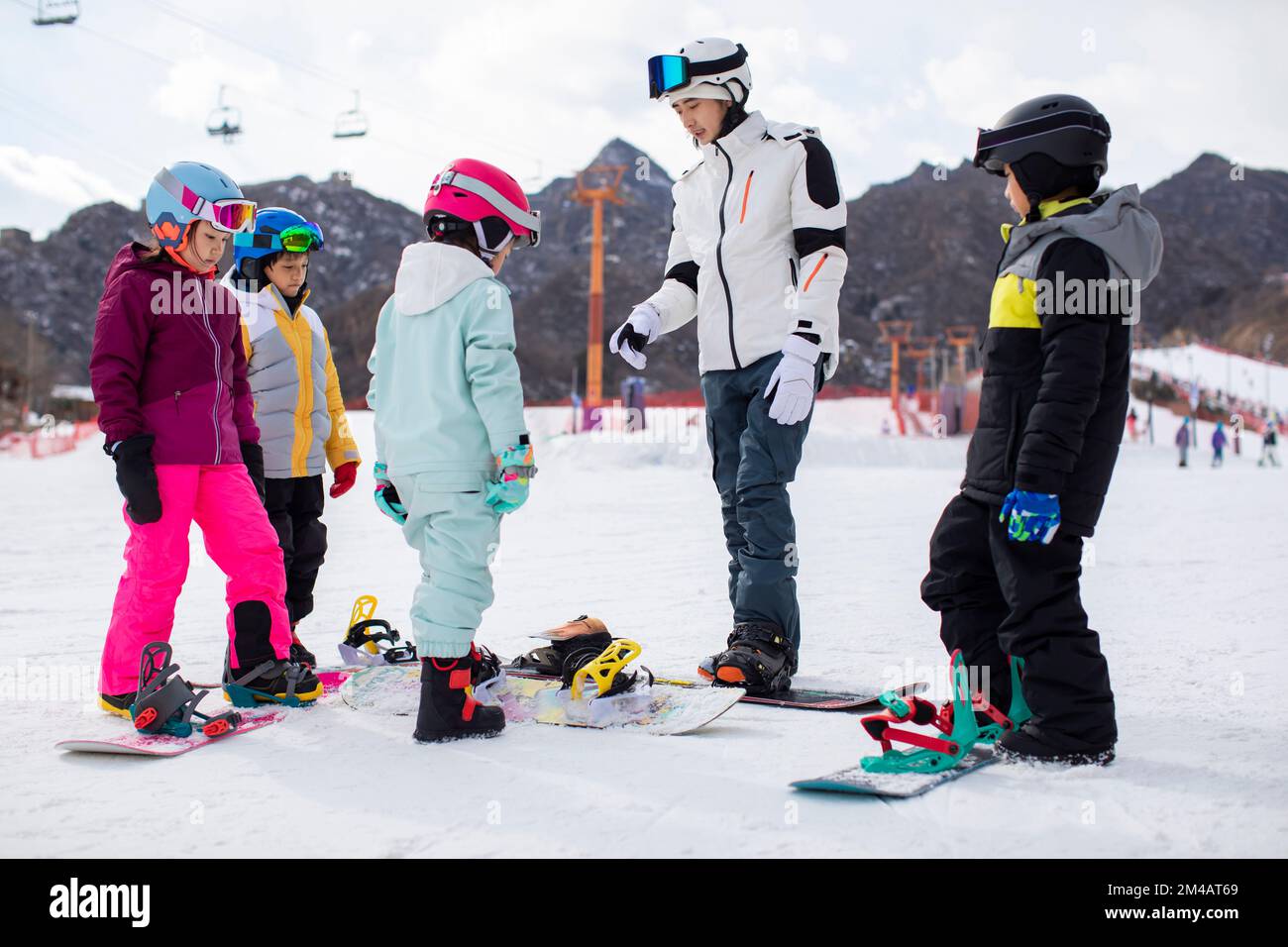 Chinese children learning how to snowboard with their coach Stock Photo ...