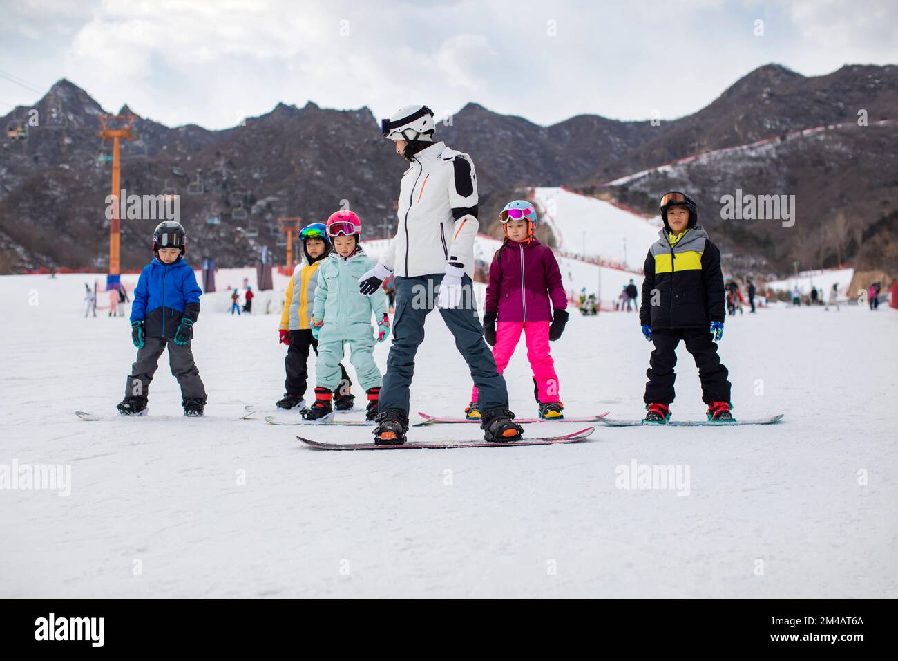 Chinese children learning how to snowboard with their coach Stock Photo ...