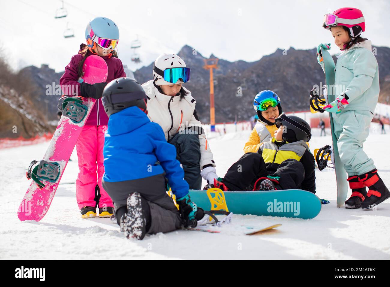 Chinese children learning how to snowboard with their coach Stock Photo ...