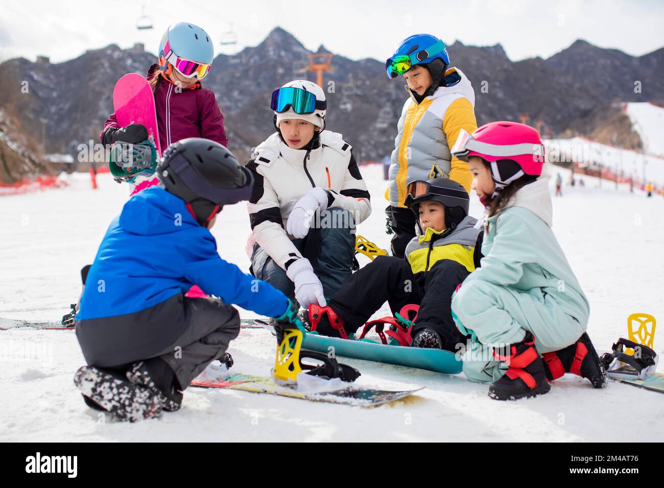 Chinese children learning how to snowboard with their coach Stock Photo ...
