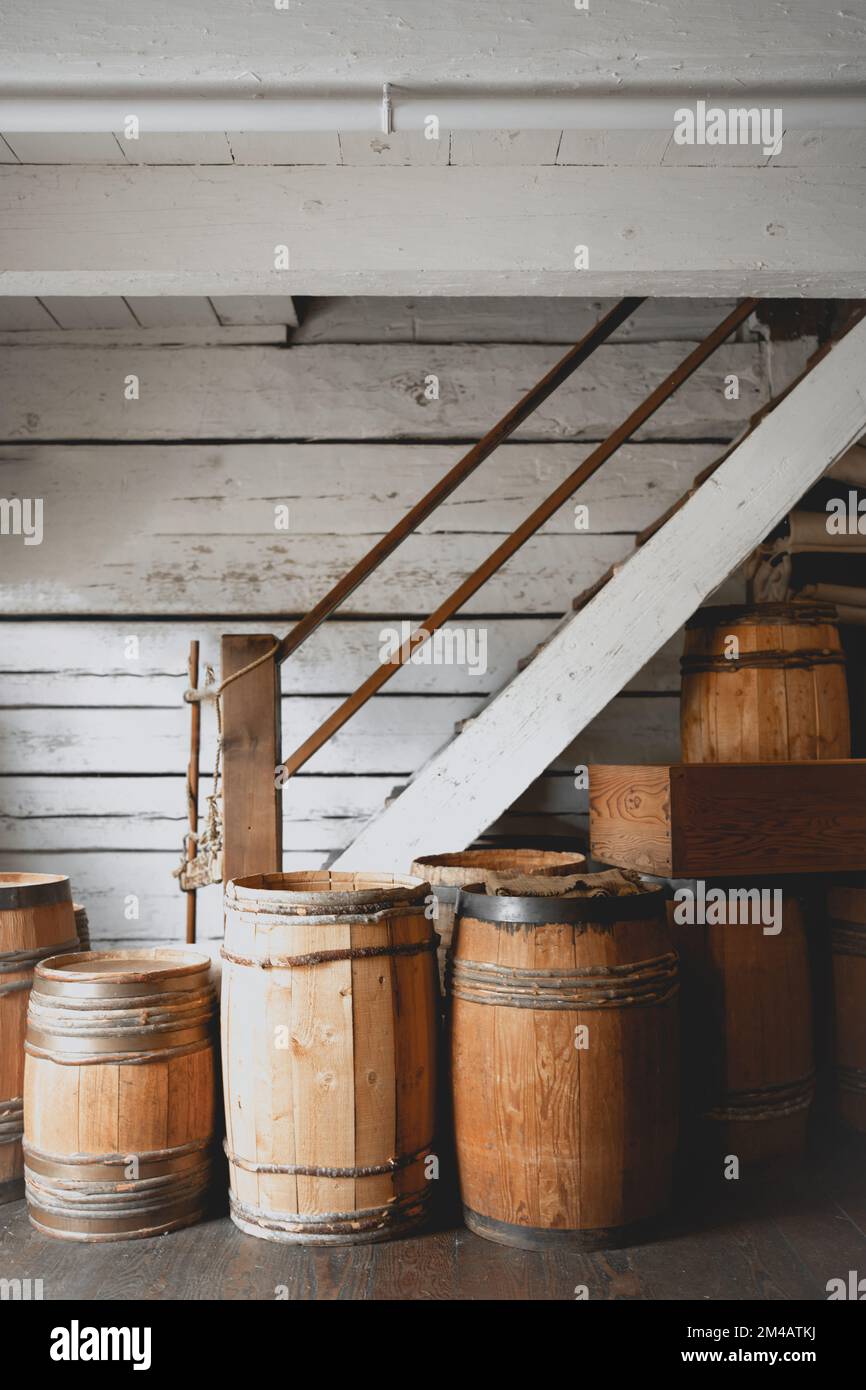 A vertical shot of old rustic wine barrels under the white wooden ...