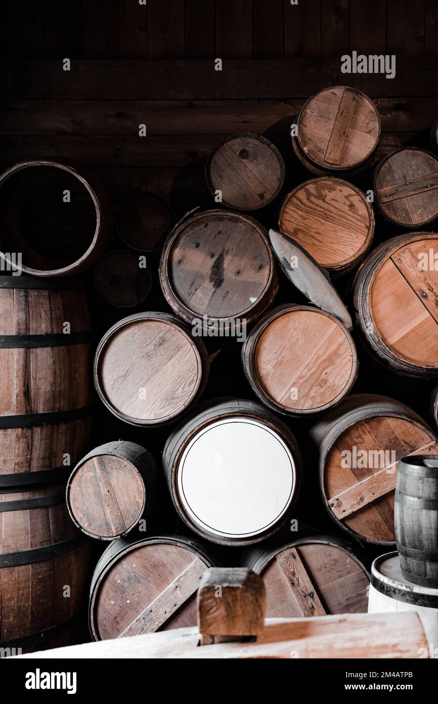 A vertical shot of stack of old wine barrels in the wooden basement ...