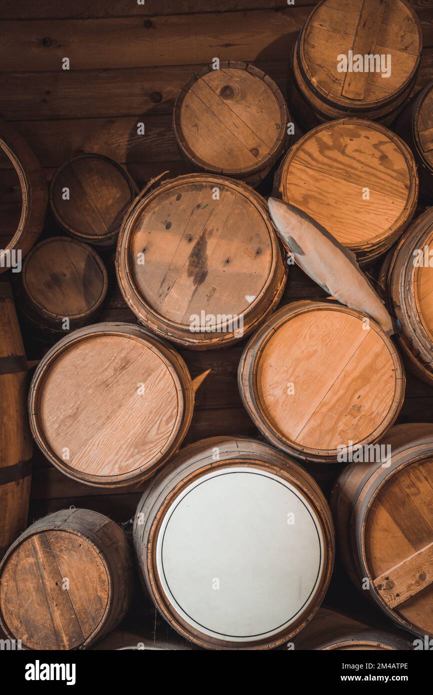 A vertical shot of stack of old wine barrels in the wooden basement ...