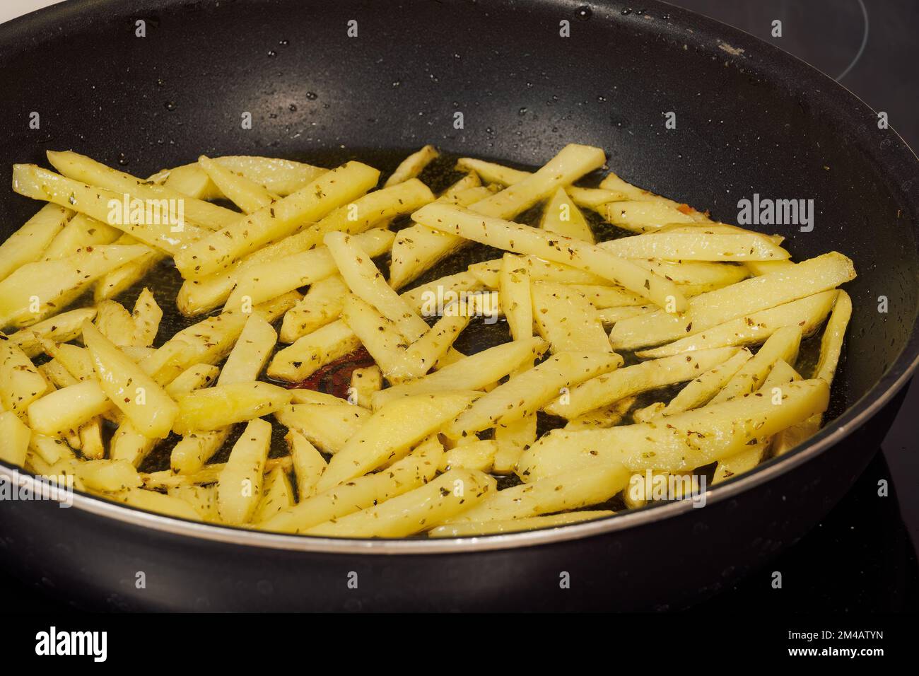 Frying French fries in hot olive oil at home kitchen close up. View of ...