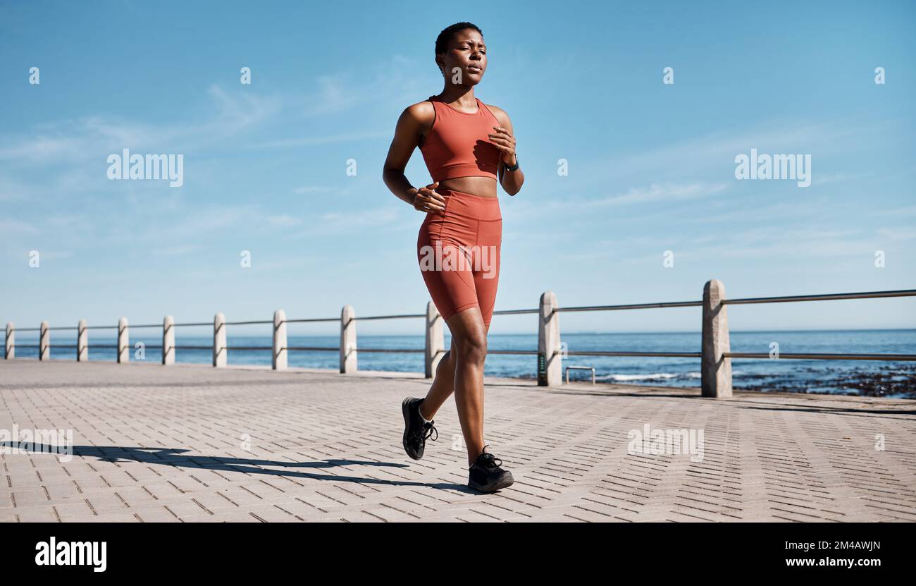 Run, black woman and beach for workout, exercise and training for ...