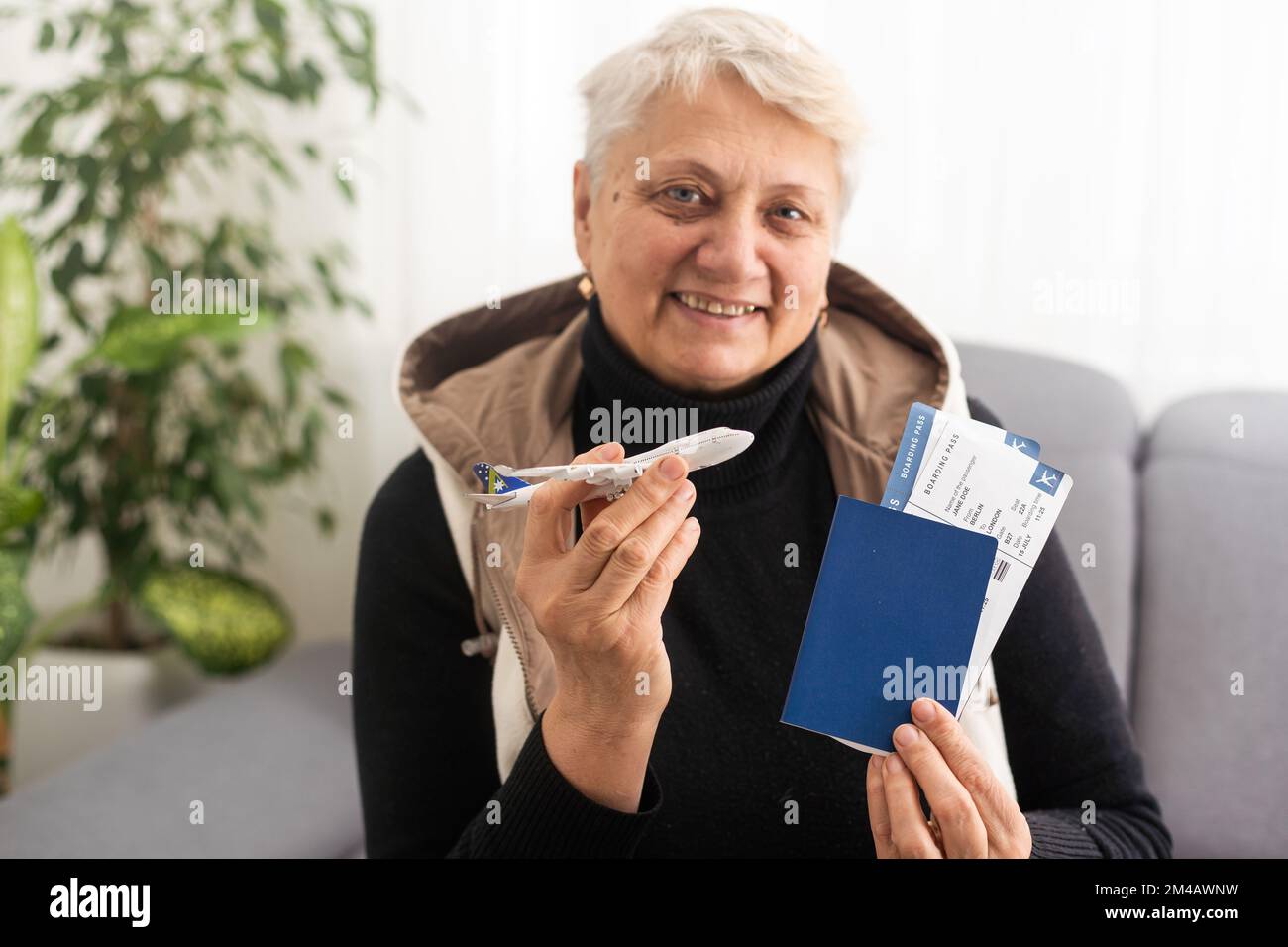 old woman holding Passport, boarding pass and toy airplane Stock Photo ...
