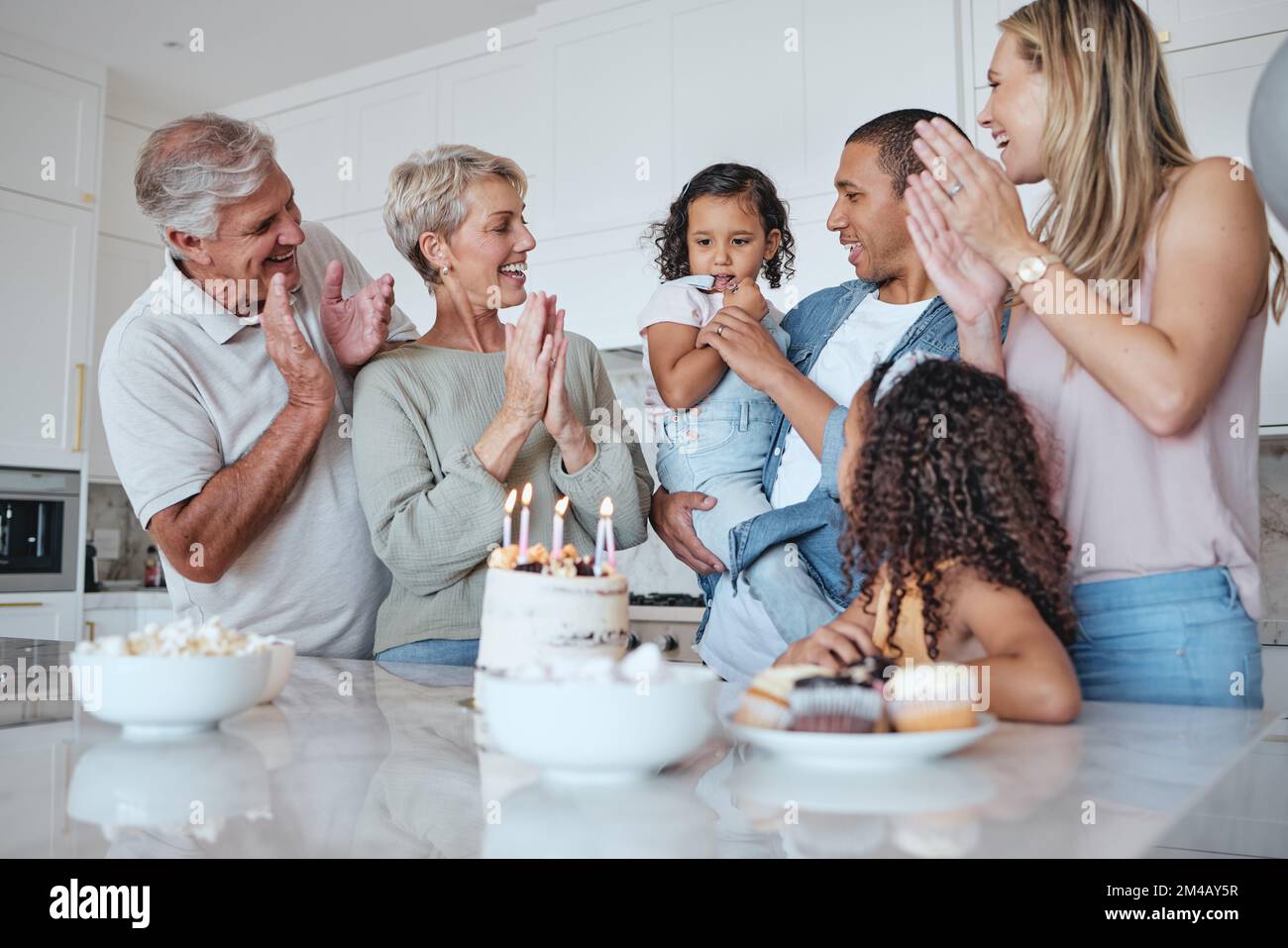 Family, birthday and cake with singing and celebration, party and ...