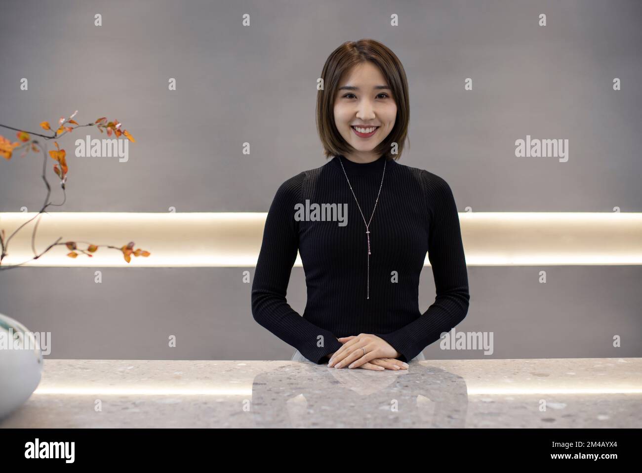 Young Chinese businesswoman standing at office reception desk Stock ...