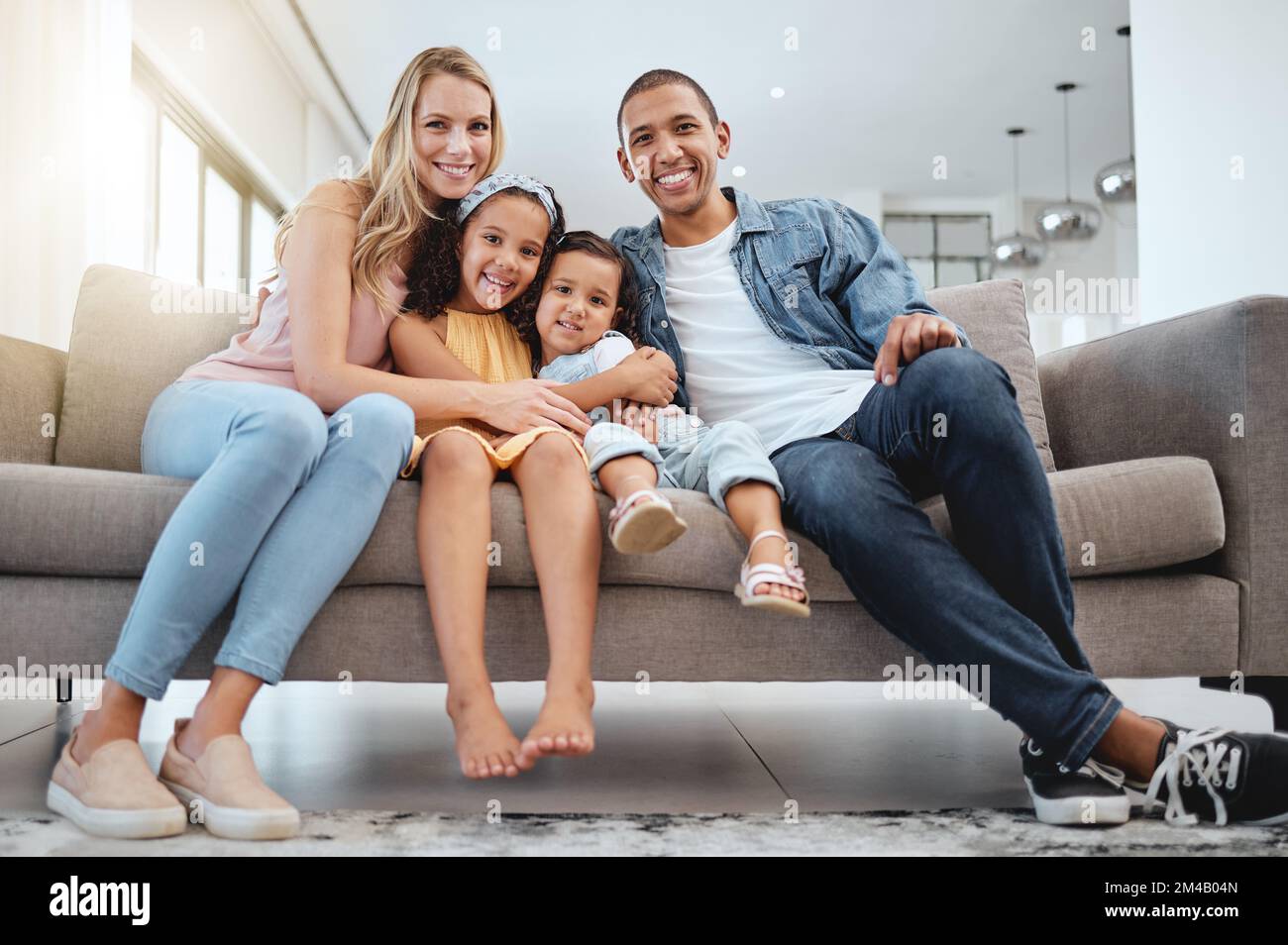 Interracial, portrait and family on sofa, love and bonding on weekend, break and smile together ...