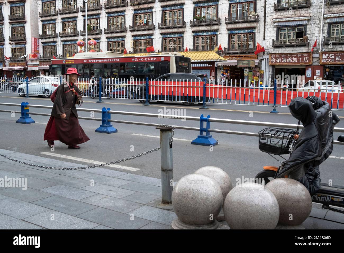 Tibetan lady dressed in traditional clothes strolls in the modern part ...