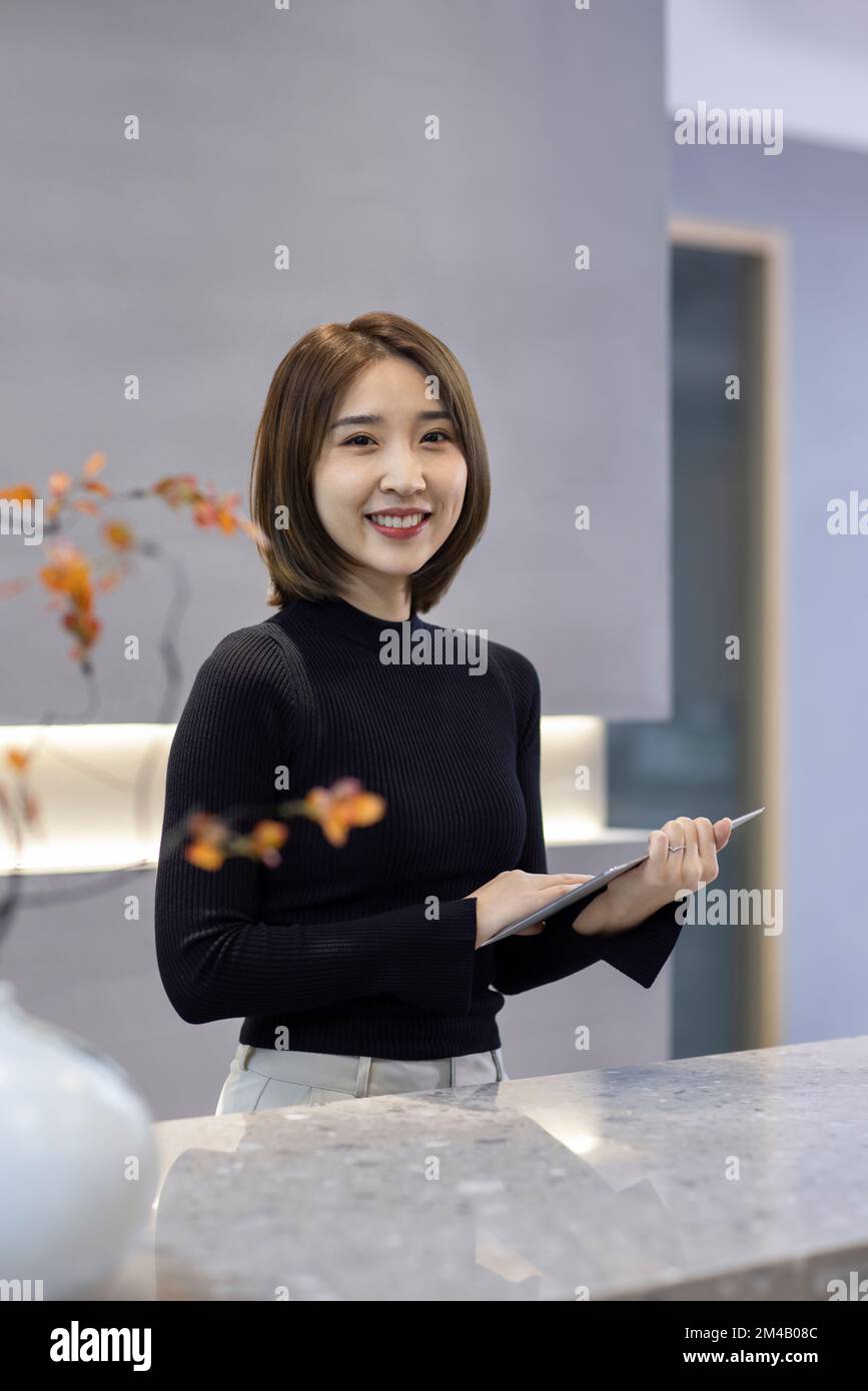 Young Chinese businesswoman standing at office reception desk Stock ...