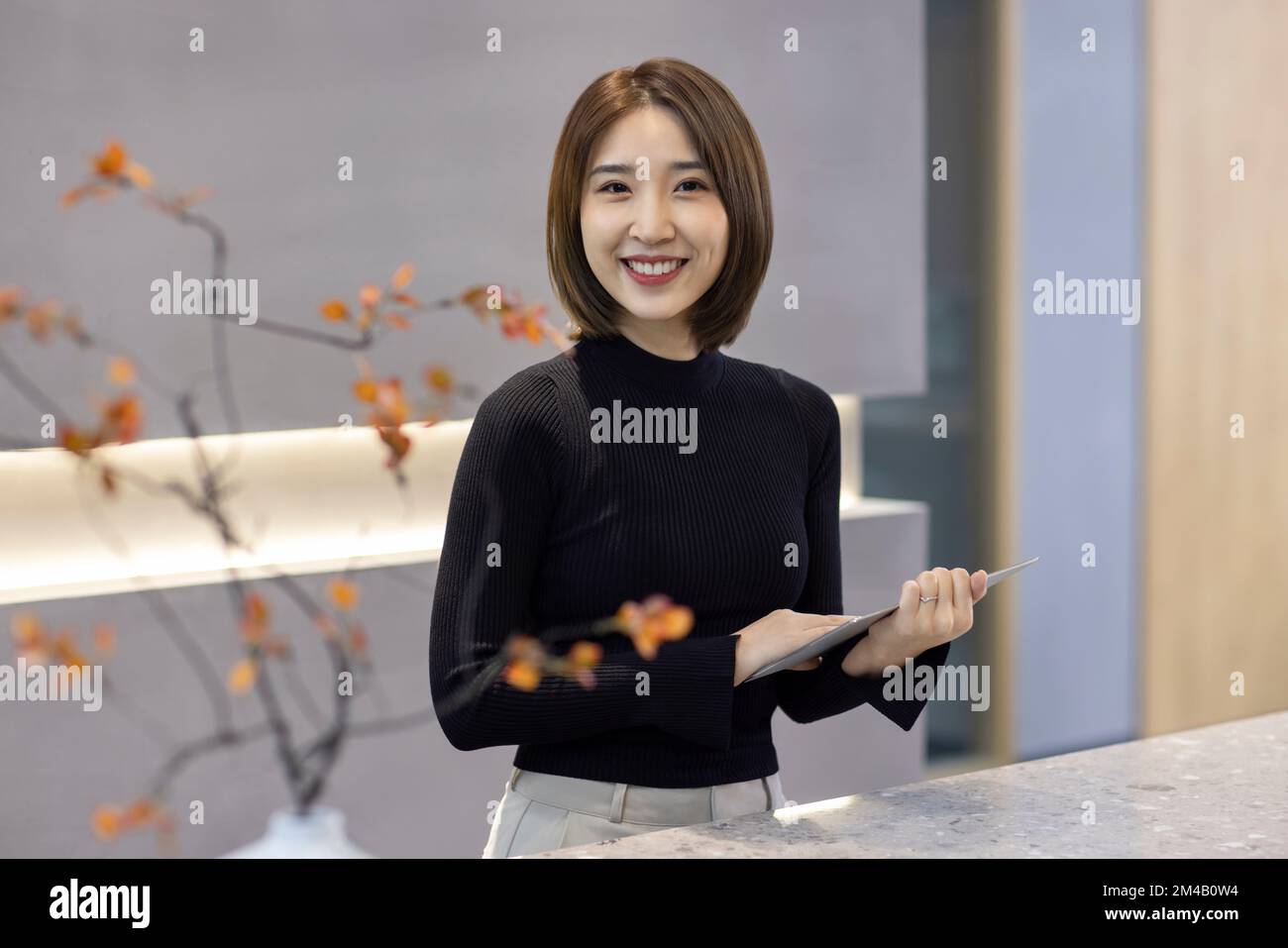 Young Chinese businesswoman standing at office reception desk Stock ...