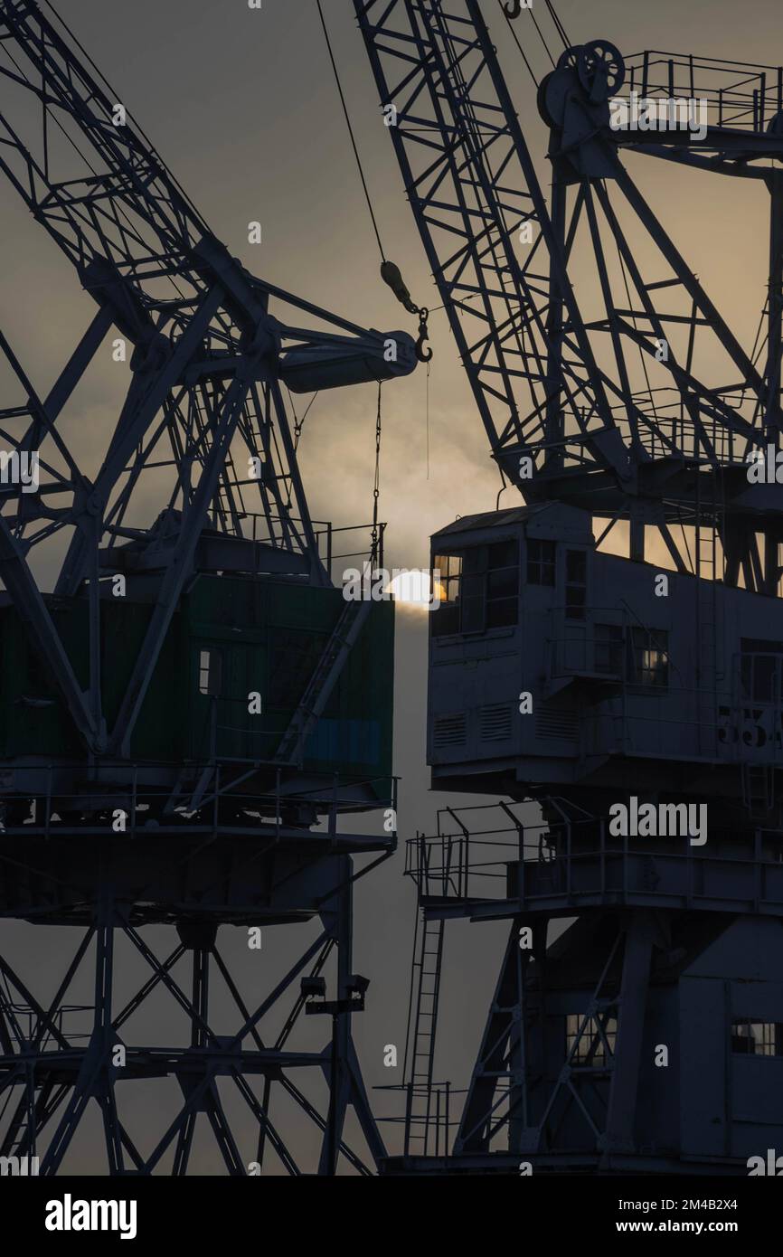 A vertical shot of tower crane cabins during the sunset Stock Photo - Alamy