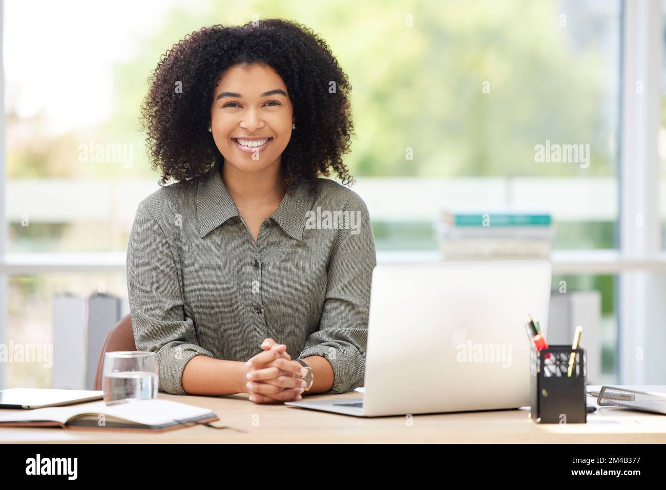 Black woman, business smile and laptop on desk while happy about leadership, success and growth ...