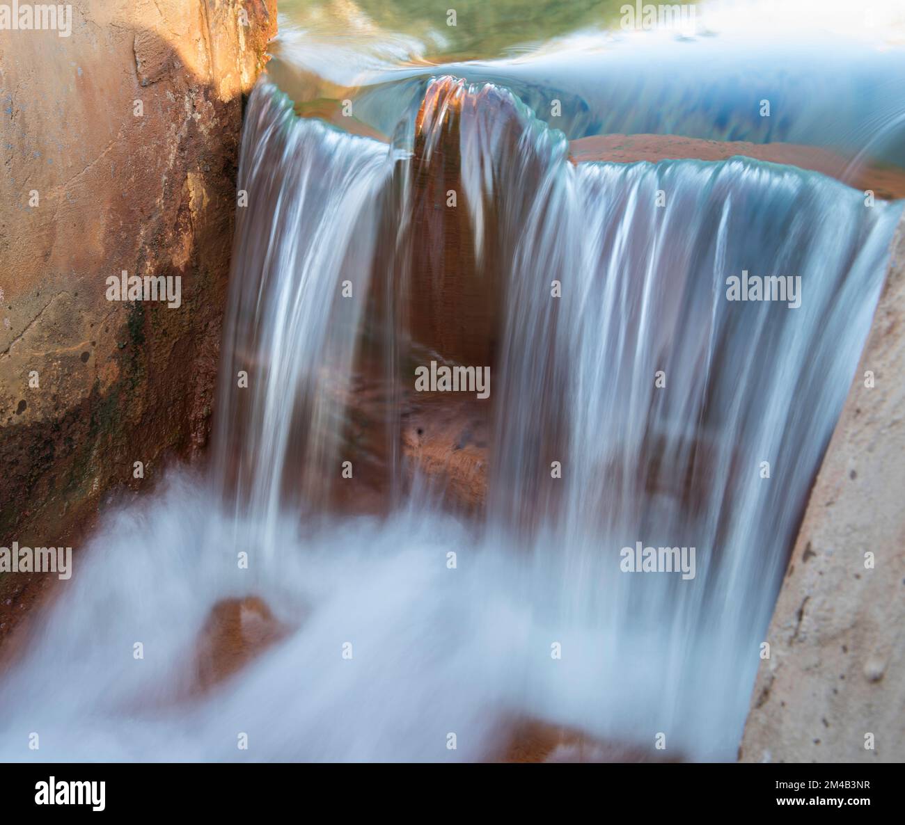 Closeup detail of blurred water in hot spring pool trough at african ...