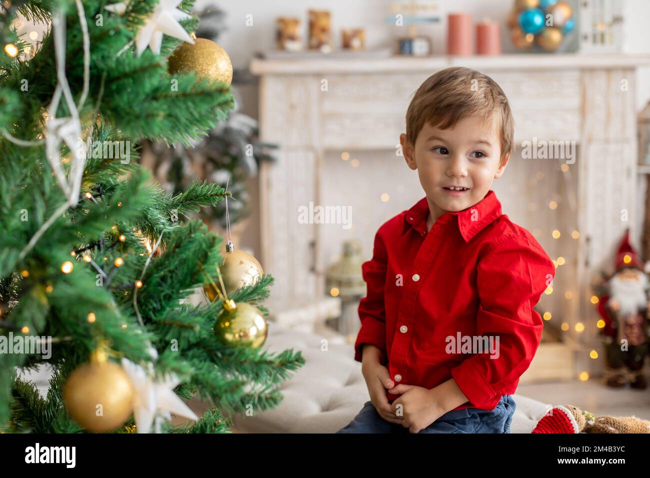 Happy cute child on Christmas, enjoying holiday, opening presents and ...