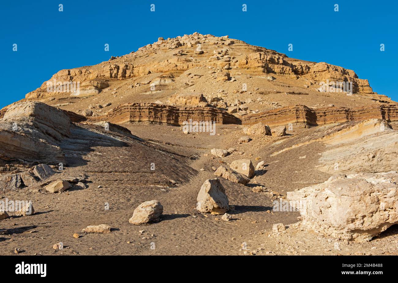 Rocky slope landscape in an arid desert environment with large pyramid ...