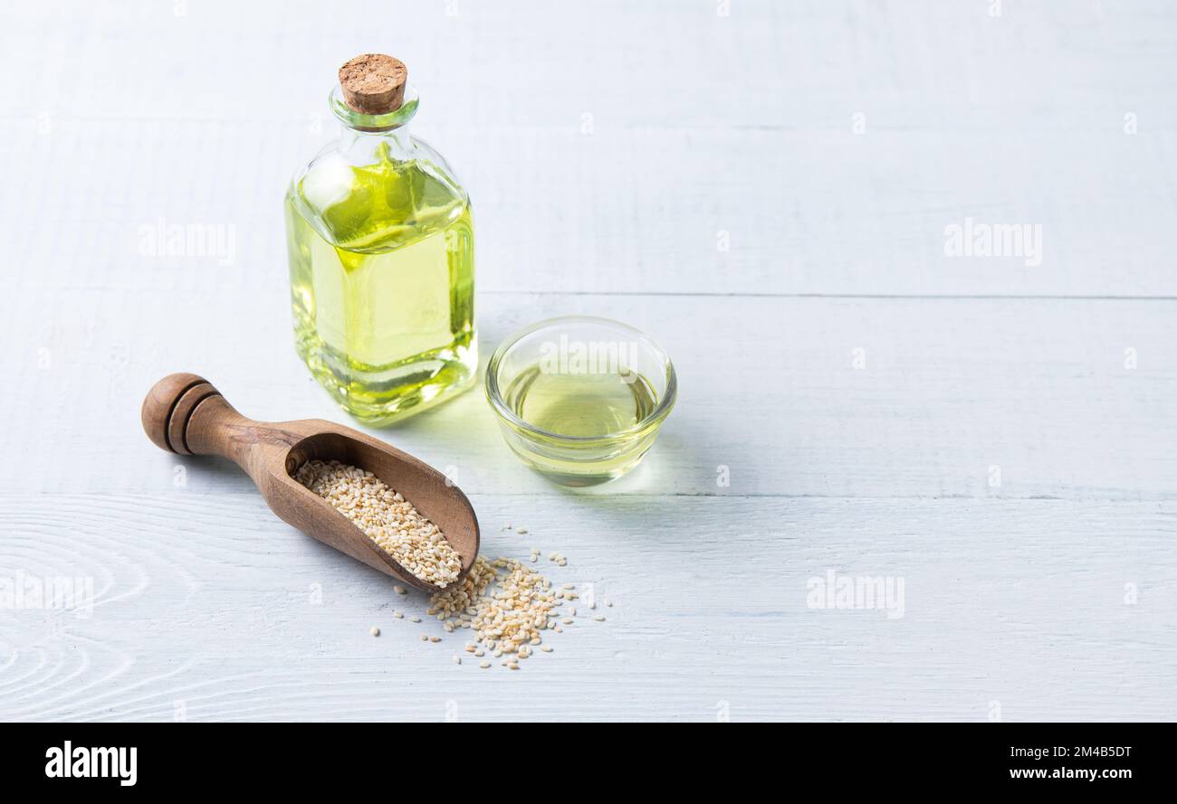Natural vegetable oil from sesame seeds in a clear bottle on the wooden ...
