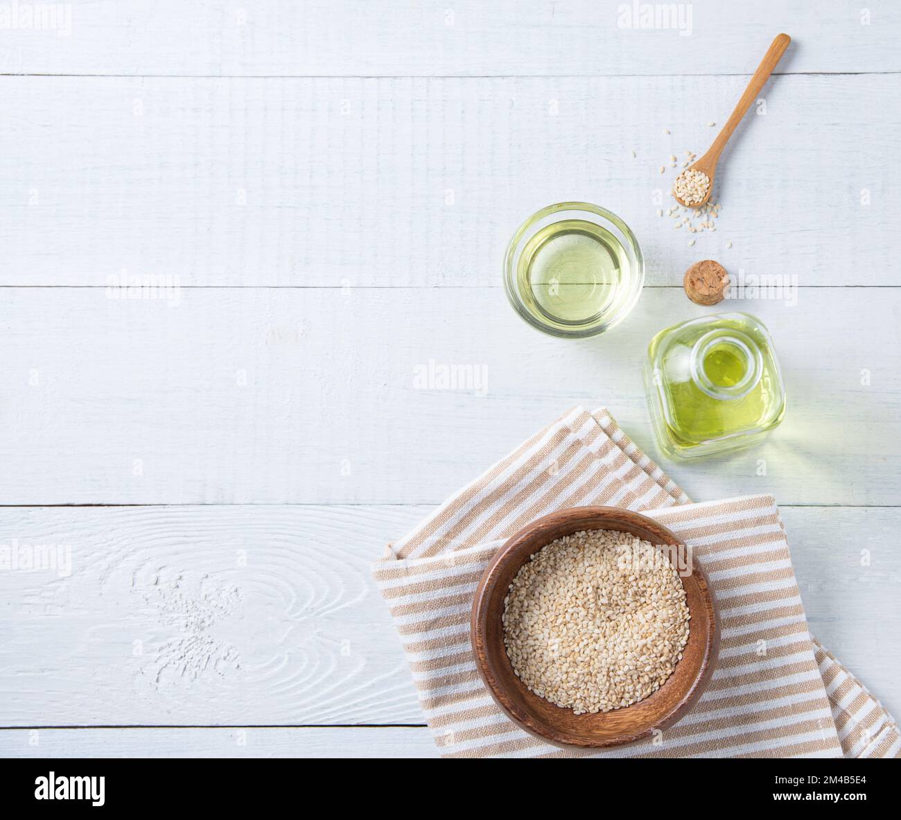 Natural vegetable oil from sesame seeds in a clear bottle on the wooden ...
