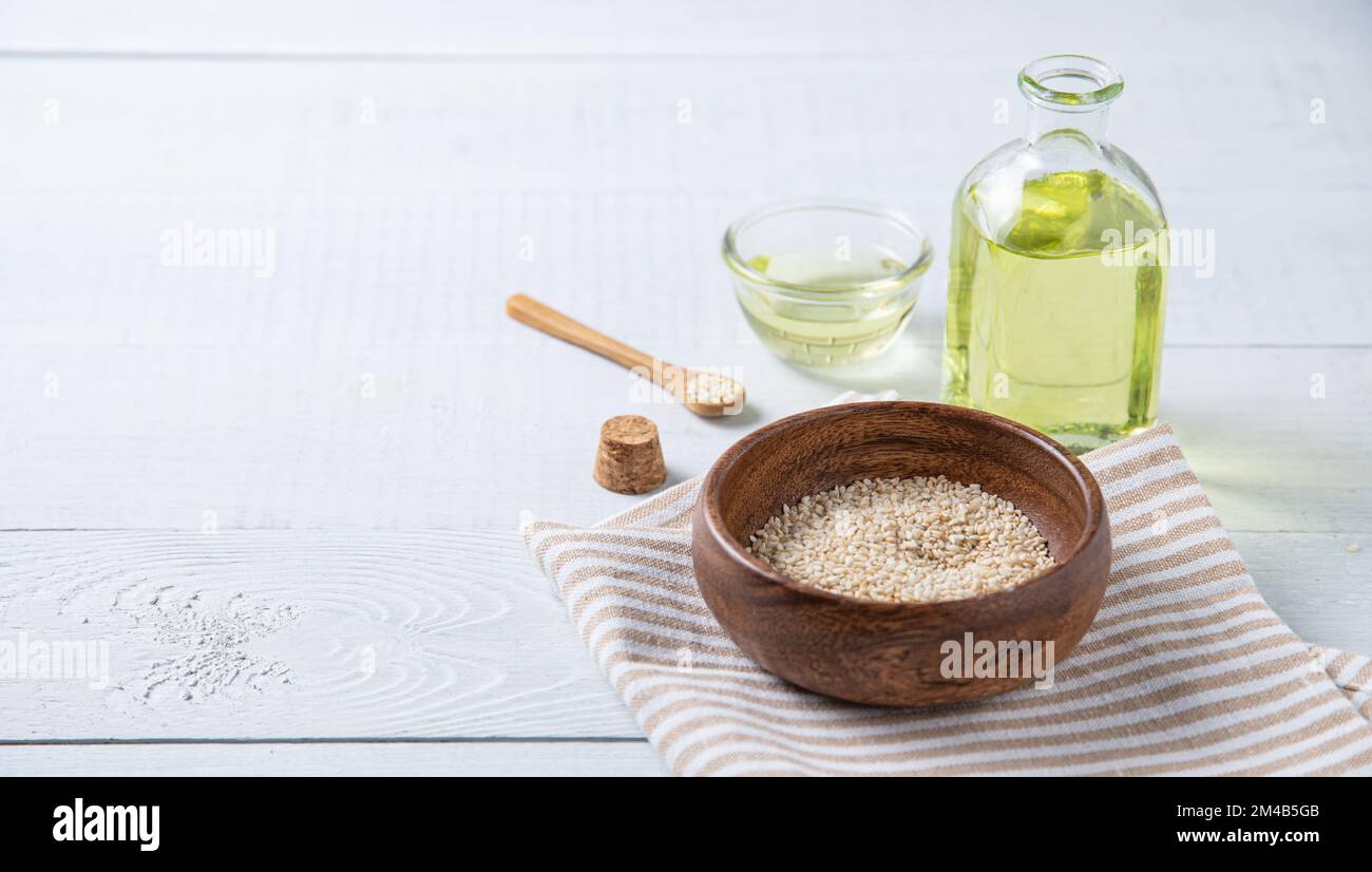 Natural vegetable oil from sesame seeds in a clear bottle on the wooden ...