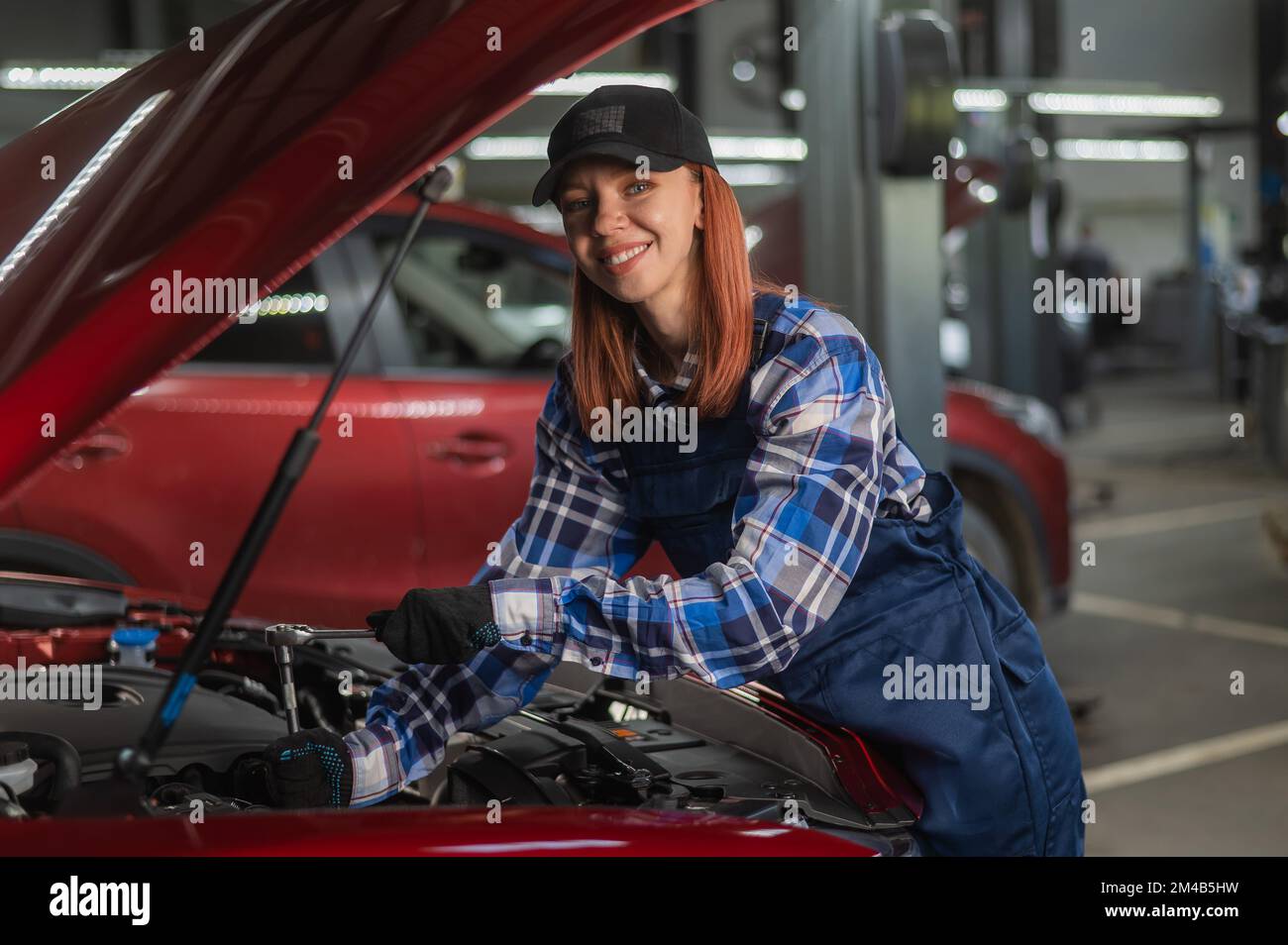 A woman auto mechanic in overalls is repairing a car Stock Photo - Alamy