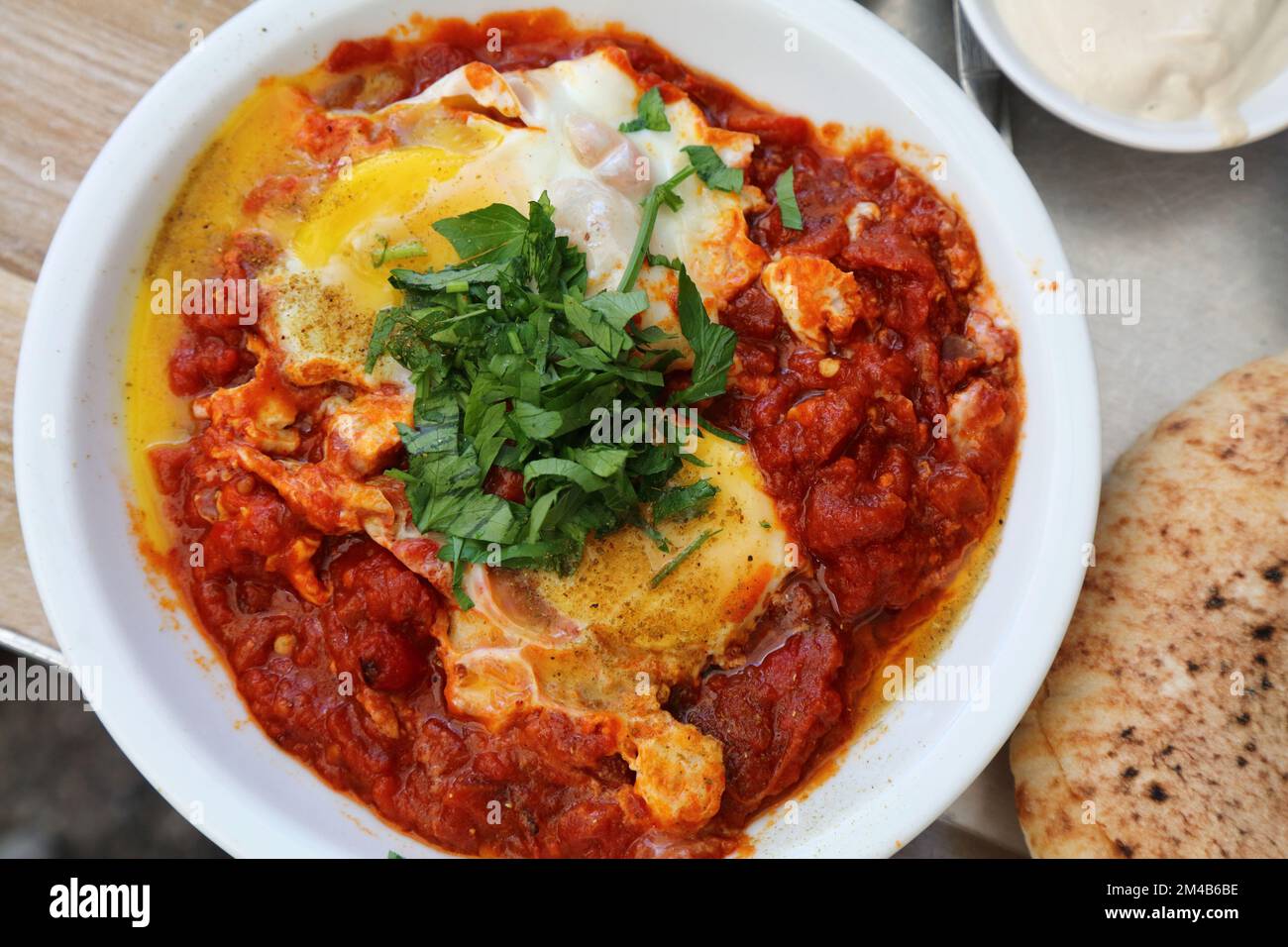 Israeli cuisine. Shakshuka lunch - poached eggs in spicy pan fried ...