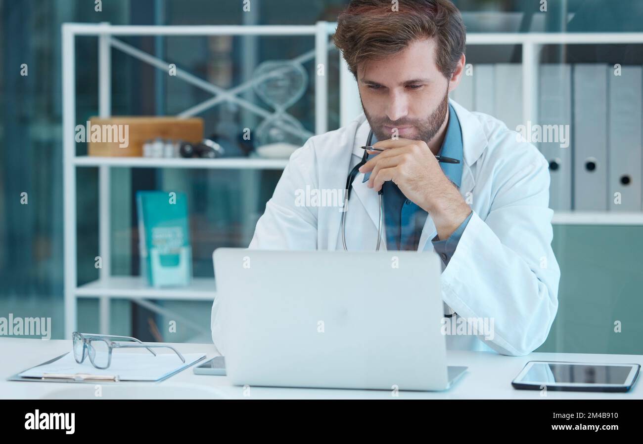 Doctor, scientist and laptop with a man reading and thinking while ...