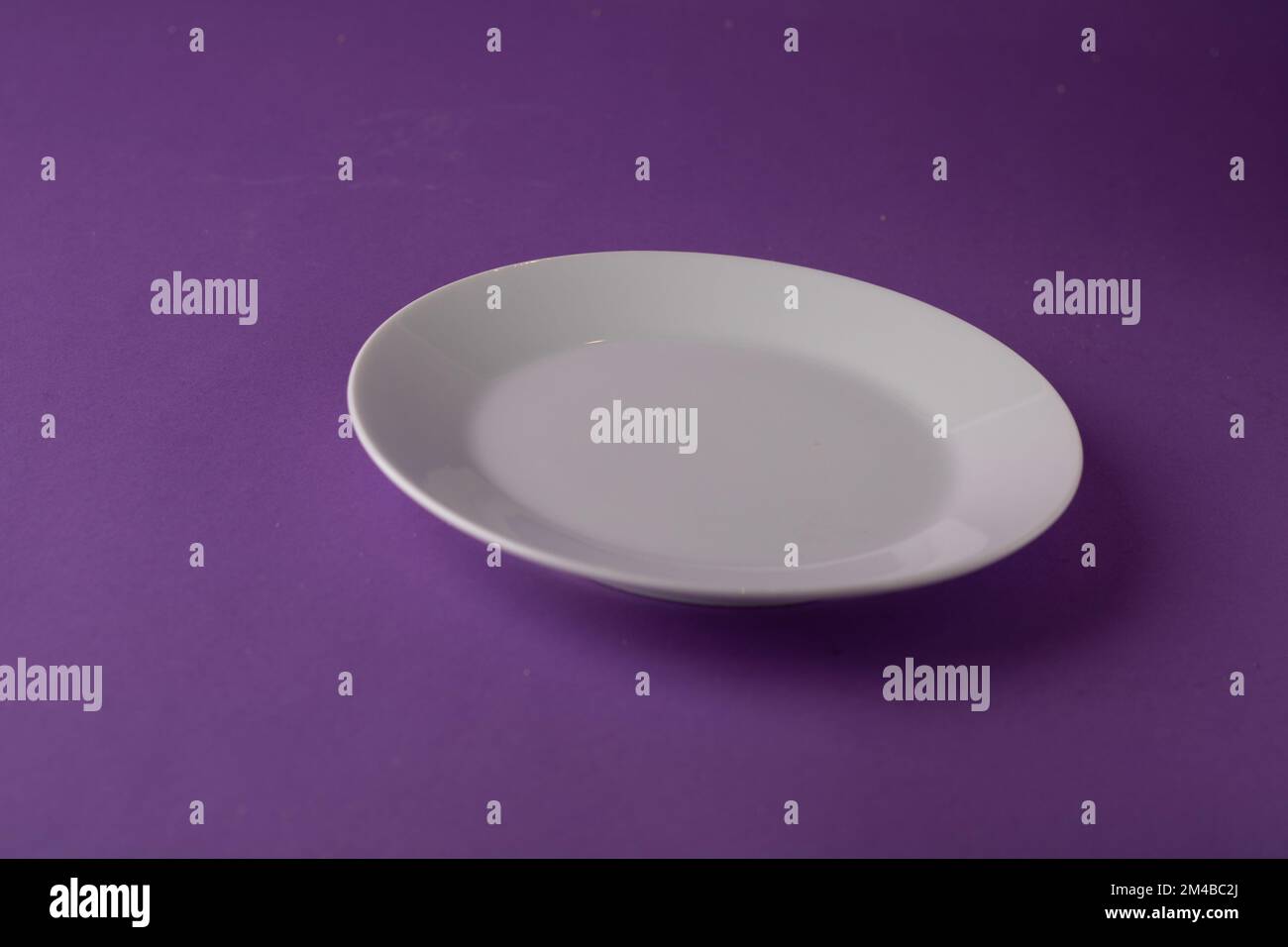 photo of an empty round plate on a purple background to cut out Stock ...