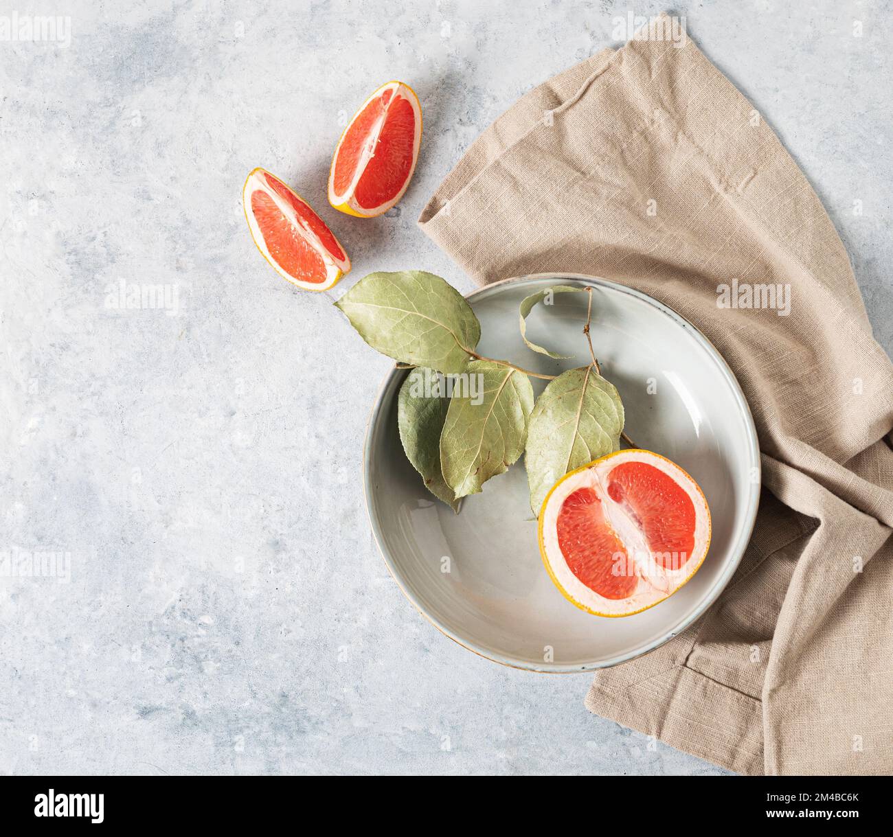 juicy red grapefruit in a plate and slices on a blue background with a ...