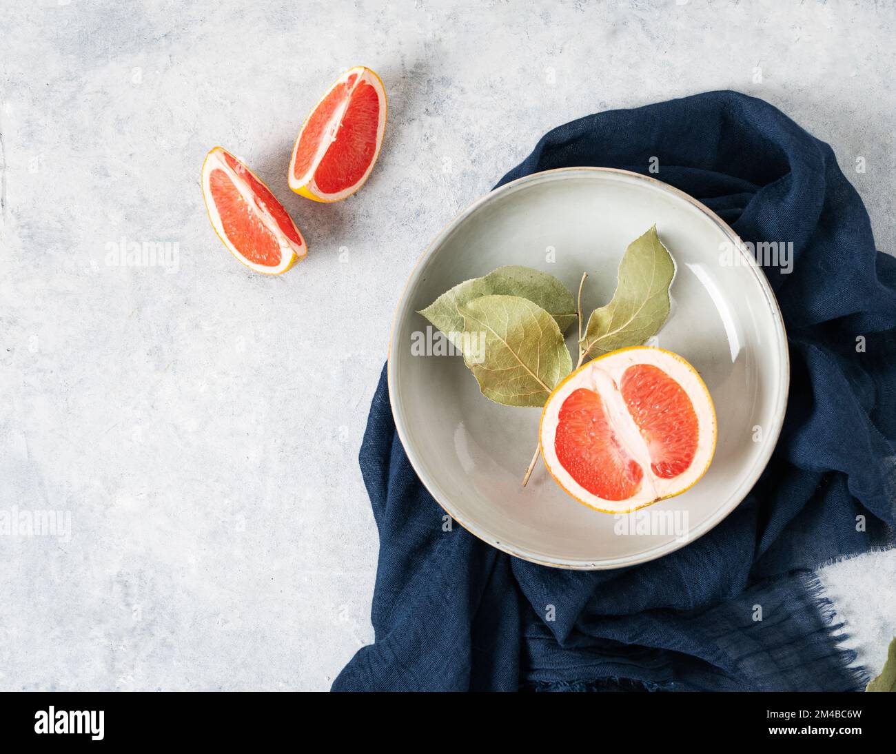 juicy red grapefruit in a plate and slices on a blue background with a ...