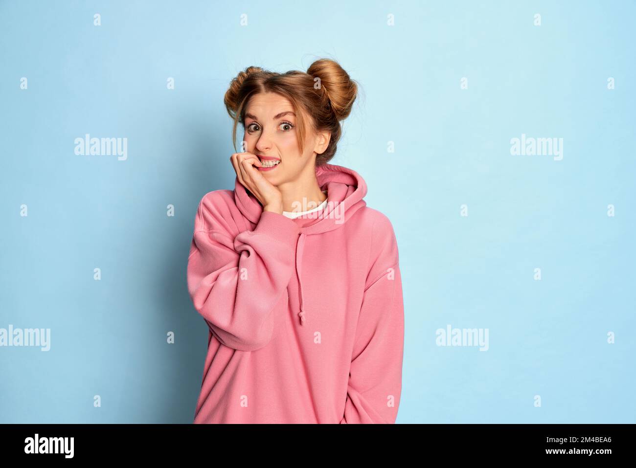 Portrait of young girl, student in pink hoodie posing with stressful ...