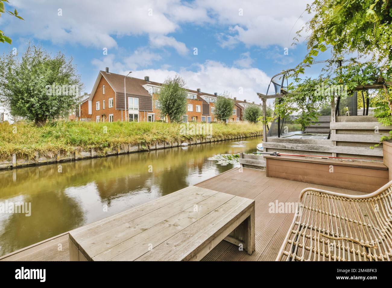 a bench on the side of a river with buildings in the background and ...