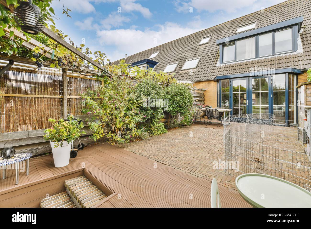 a backyard area with wooden decking and green plants on the ground in ...